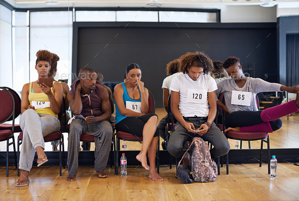 Shot of a group of young dancers looking anxious while waiting for ...