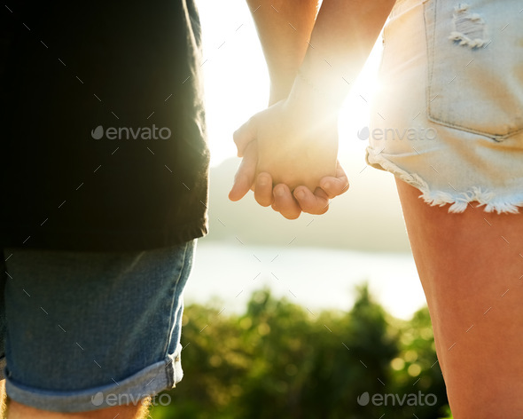 Rearview shot of an unrecognizable young couple standing hand in hand ...