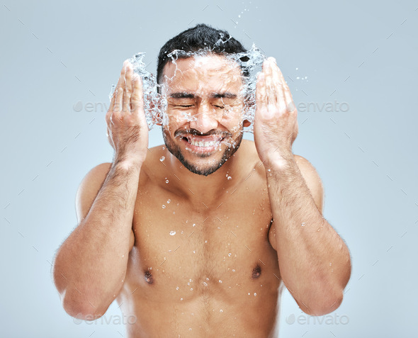 Studio shot of a handsome young man washing his face against a grey background Stock Photo by ...