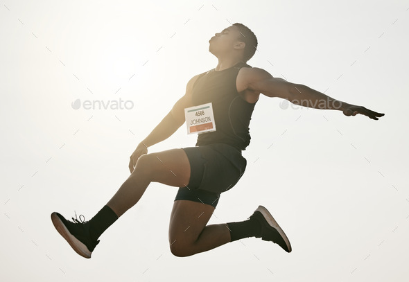 Low angle shot of a handsome young man leaping high into the air during ...