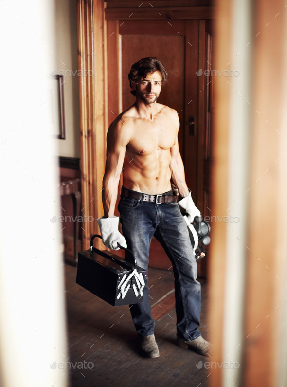 Attractive young handyman standing shirtless while holding his tools ...
