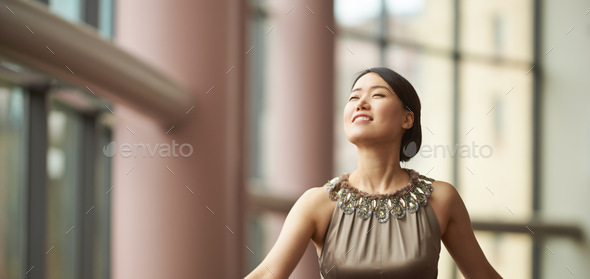 Shot of an elegantly dressed young woman dancing through a large ...