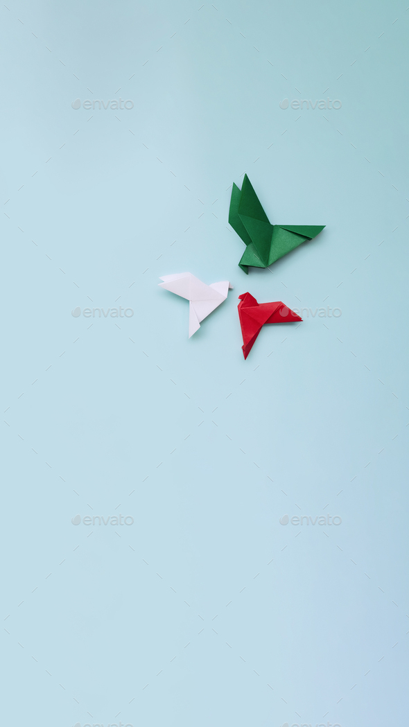 three paper origami pigeons red, white, green on light background ...