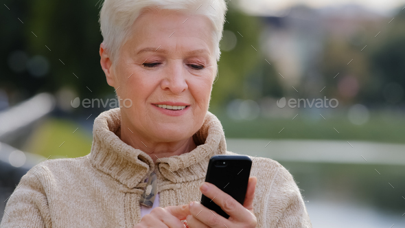 Closeup gray-haired Mature woman texting messaging on modern smartphone ...
