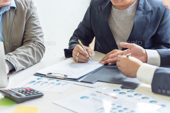 Signing Contracts. A group of business people sign a joint investment ...