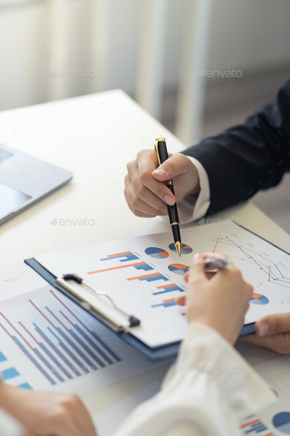 Close up. two business people pointing graph talking, planning analyze ...