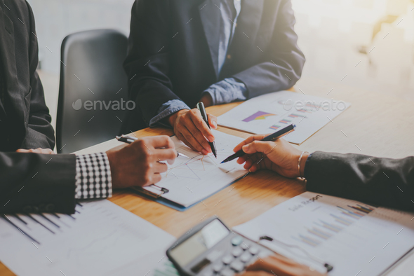 Business people gather to analyze marketing and investment information ...