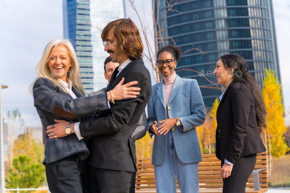 Middle-aged multi-ethnic businessmen and businesswomen giving each ...
