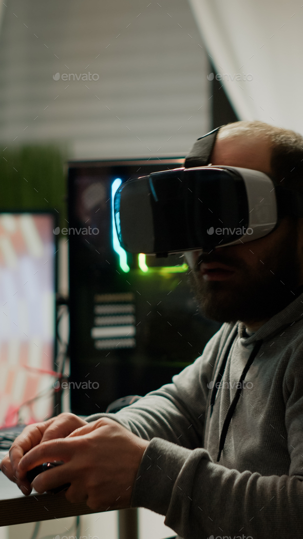 Videogame player with VR headset raising hands after winning space ...