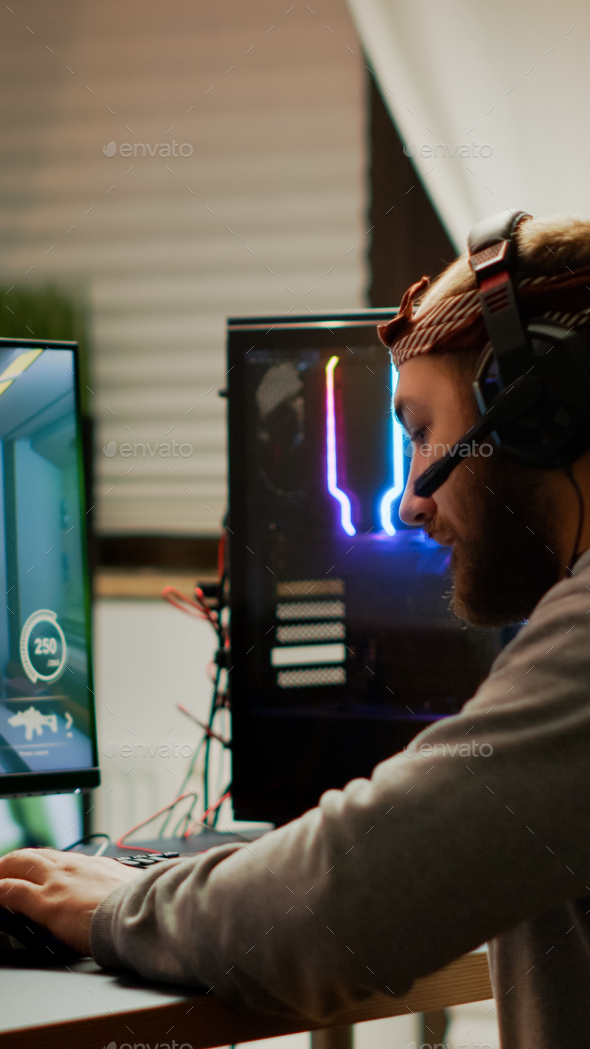 Cyber sport gamer wearing headphones playing first person shooter ...