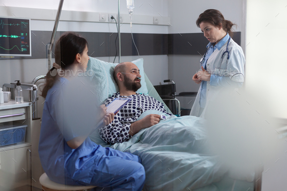 Medical team monitoring sick man explaining disease symptom Stock Photo ...