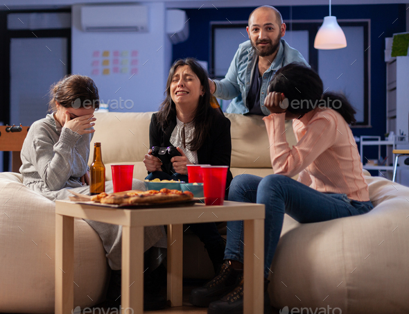 Diverse group of mates bonding while playing video game Stock Photo by ...