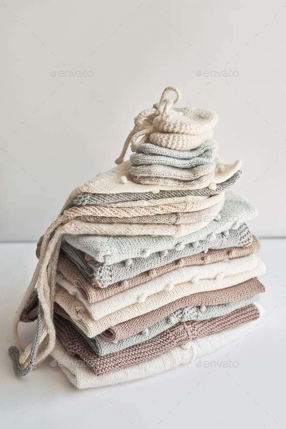 Stack of knitted clothes. Baby clothes. Needlework, hobby, knitting ...