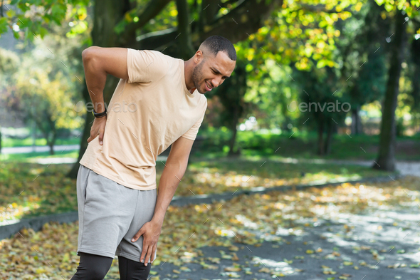 Tired man after jogging in park, hispanic man has severe pain in back ...