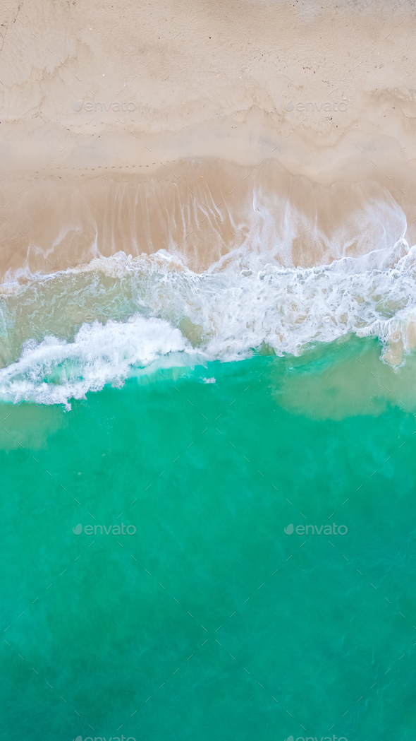 Top view at a tropical beach with waves and blue ocean Drone aerial ...