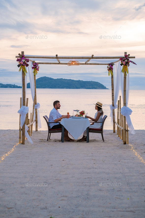 Romantic dinner on the beach in Phuket Thailand, couple man and woman having dinner on the beach ...