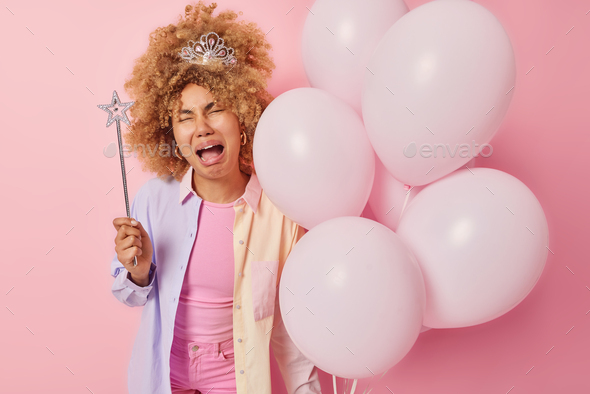 Upset doleful woman cries from despair holds inflated balloons and ...