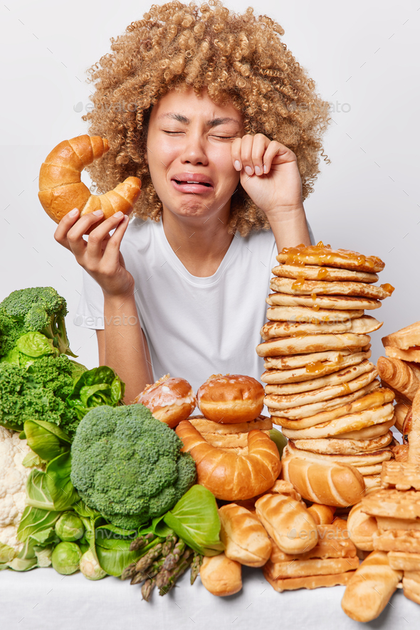 Unhealthy diet and weight loss concept. Doleful curly haired woman ...