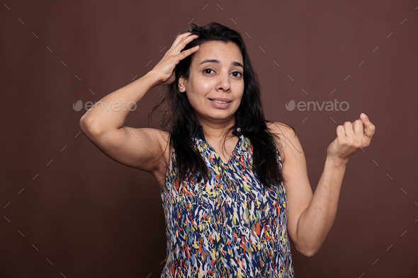 Thoughtful indian woman rubbing head with confused facial expression ...