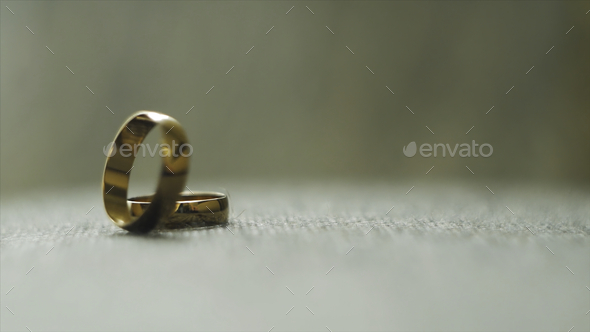 One gold wedding ring rolled to another. Video. Wedding rings. Two well ...