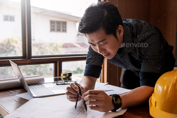Engineer man working in the office, Drawing the construction project ...