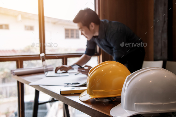 Engineer man working in the office, Drawing the construction project ...