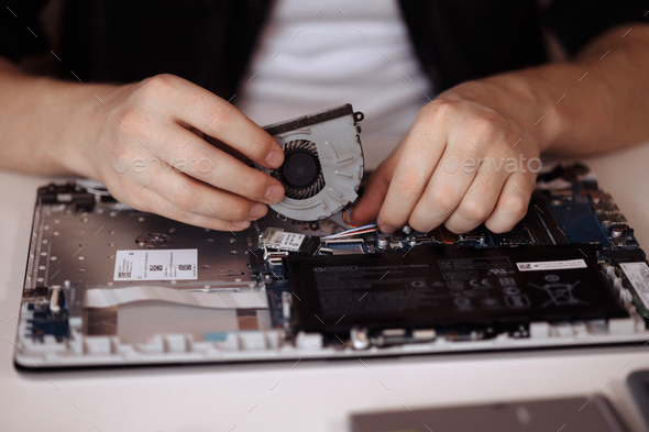 Disassembling a laptop with a screwdriver in a repair shop. Stock Photo ...