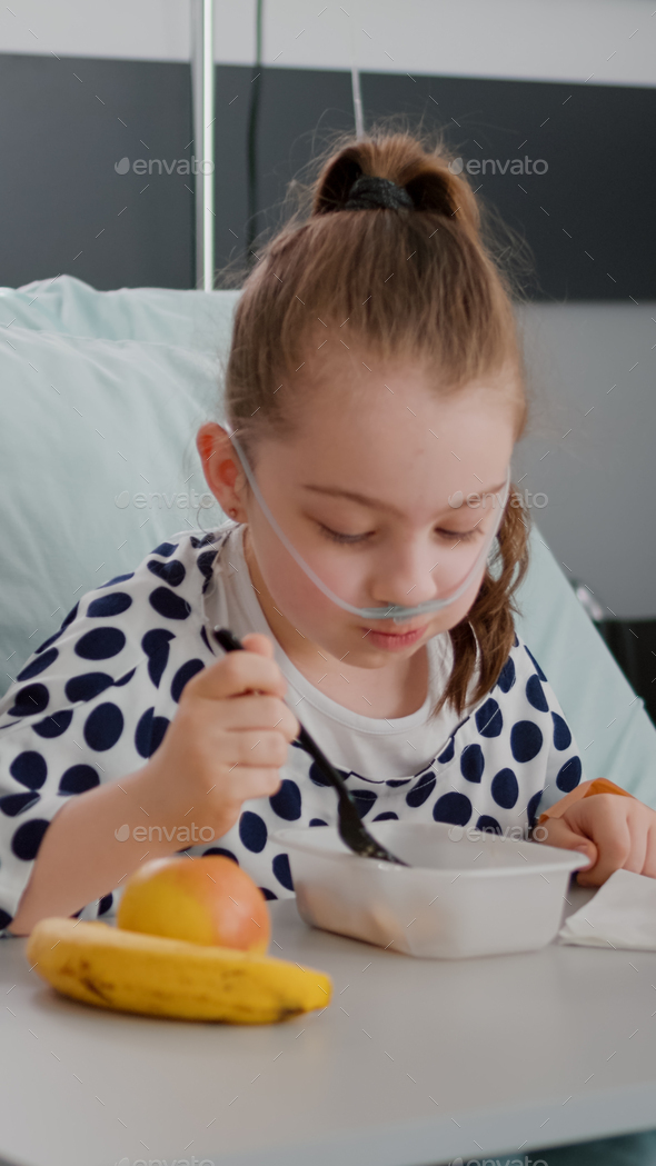 Mother sitting with sick daughter while eating healthy food meal in ...