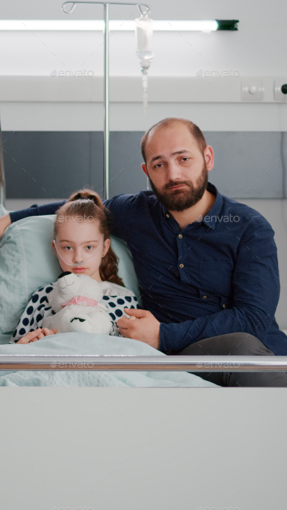 Portrait of worried family looking into camera in hospital ward during ...