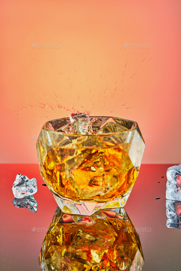 Crystal goblet with luxury whiskey and ice cubes side view on gradient ...