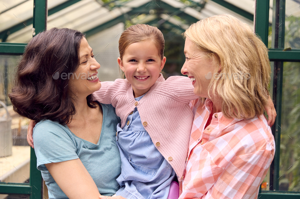Portrait Of Same Sex Family With Two Mature Mums Hugging Daughter As ...