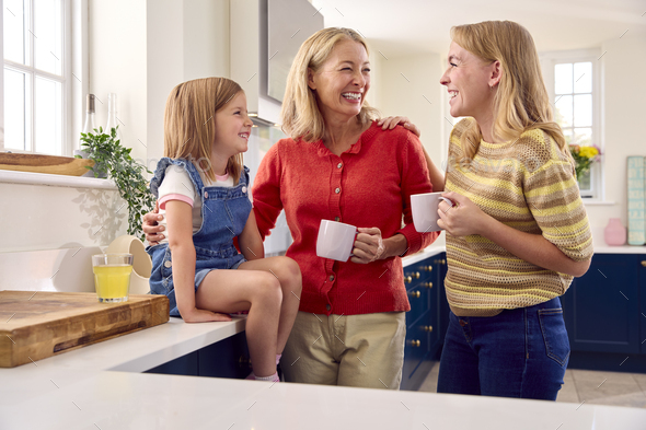 Same Sex Family With Two Mature Mums And Daughter Sitting In Kitchen ...