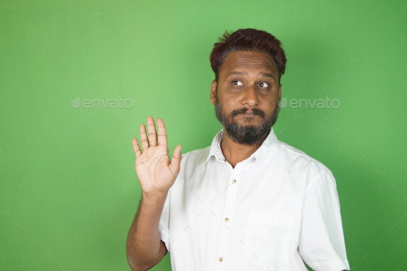 Indian old men standing with his hand up on the green background Stock ...