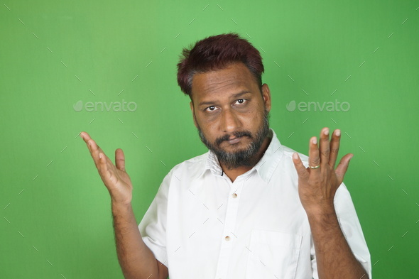 Indian adult man standing with his hands up on the green background ...