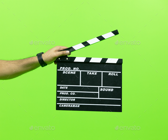Men's hand holding camera slate for the filming isolated on green ...