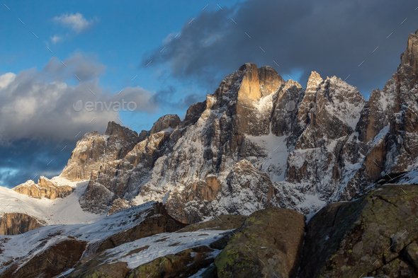Low angle shotof the snow-covered mountain peak under the cloudy sky ...