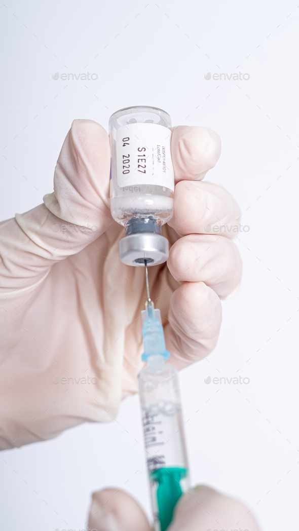 Selective focus shot of a hand holding an injection syringe with ...