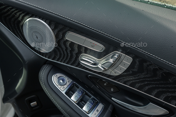 Closeup shot of a modern car door handle interior details with controls ...