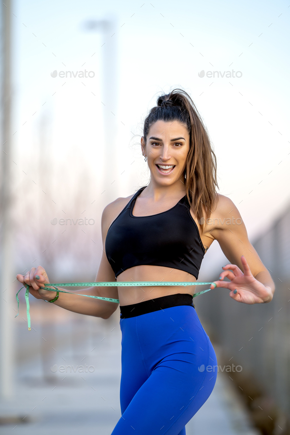 Slim woman measures her waist with a tape measure Stock Photo by ...