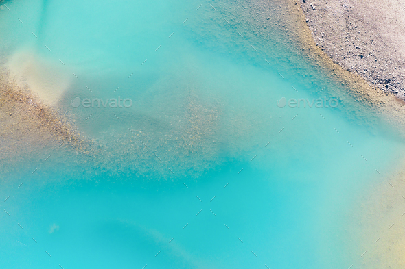 Clear azure water in a mountain lake. The shore with stones. View of ...