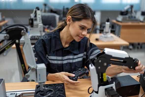 Girl engineer sitting in robot fabrication room quality checking ...