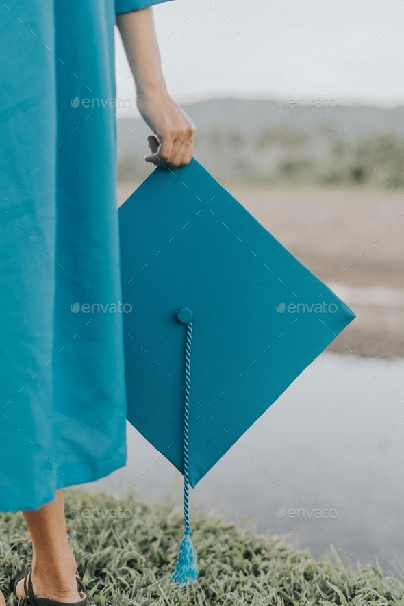 Potrait of a Filipino Woman Holding her Graduation Cap and Gown Stock ...