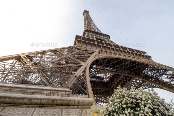 Low angle shot of the famous Eiffel Tower under a bright sky in Paris ...