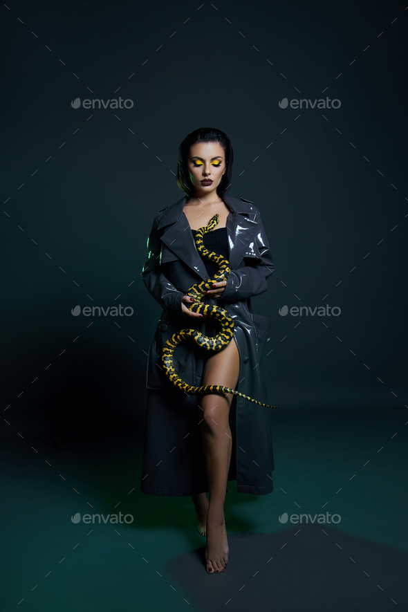 Beauty woman python yellow snake around her neck on latex shiny ...