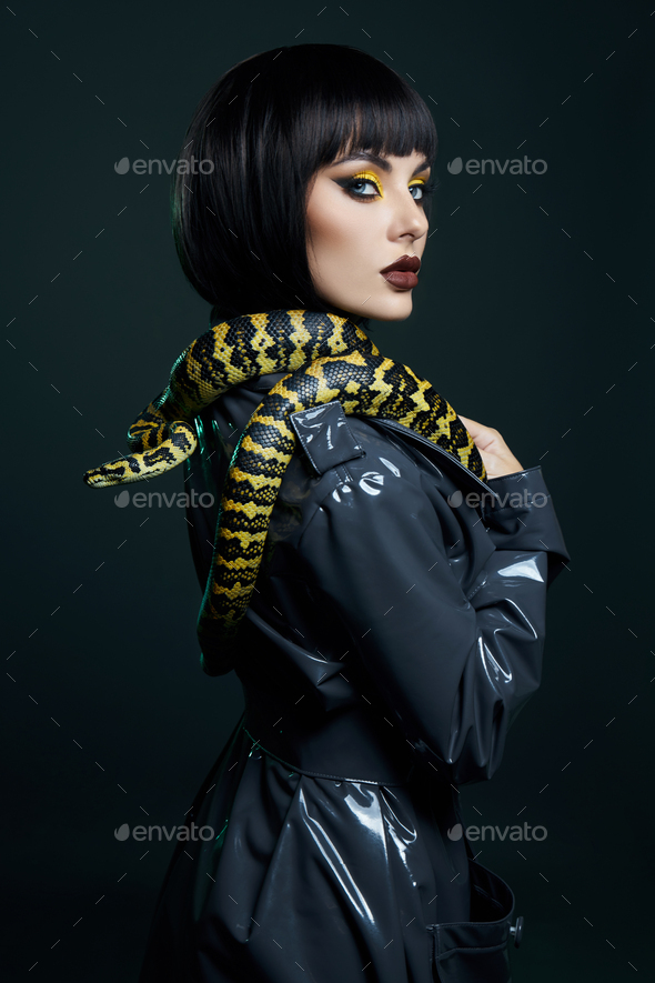 Beauty woman python yellow snake around her neck on latex shiny ...