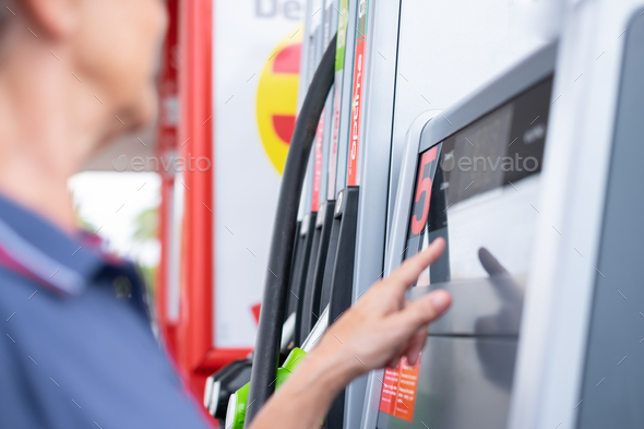 Woman at self-service fuel pump in European gas station types on the ...