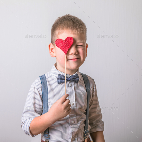 smiling boy holding a red heart on eays symbol of love Backgrounds for ...
