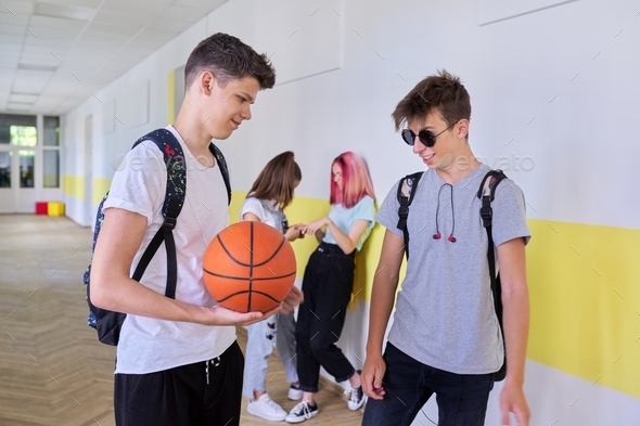Group of teenage students talking standing outside school building ...