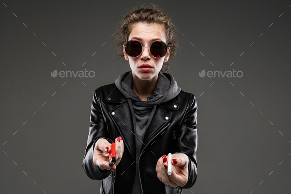 Caucasian girl with rough facial features in a black jacket holds a ...