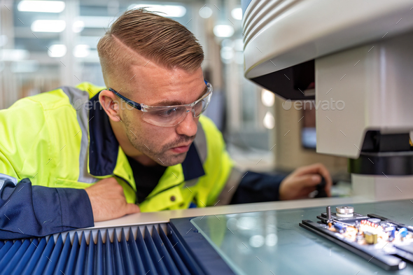 Engineer sitting in robot fabrication room use measuring microscope ...
